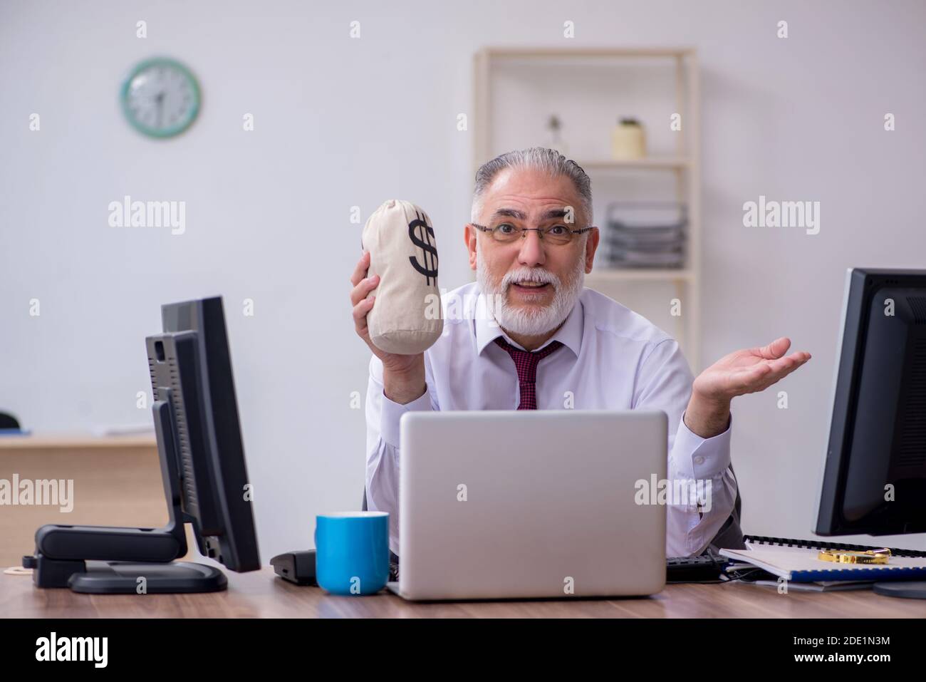Old boss sitting at desktop in the office Stock Photo - Alamy
