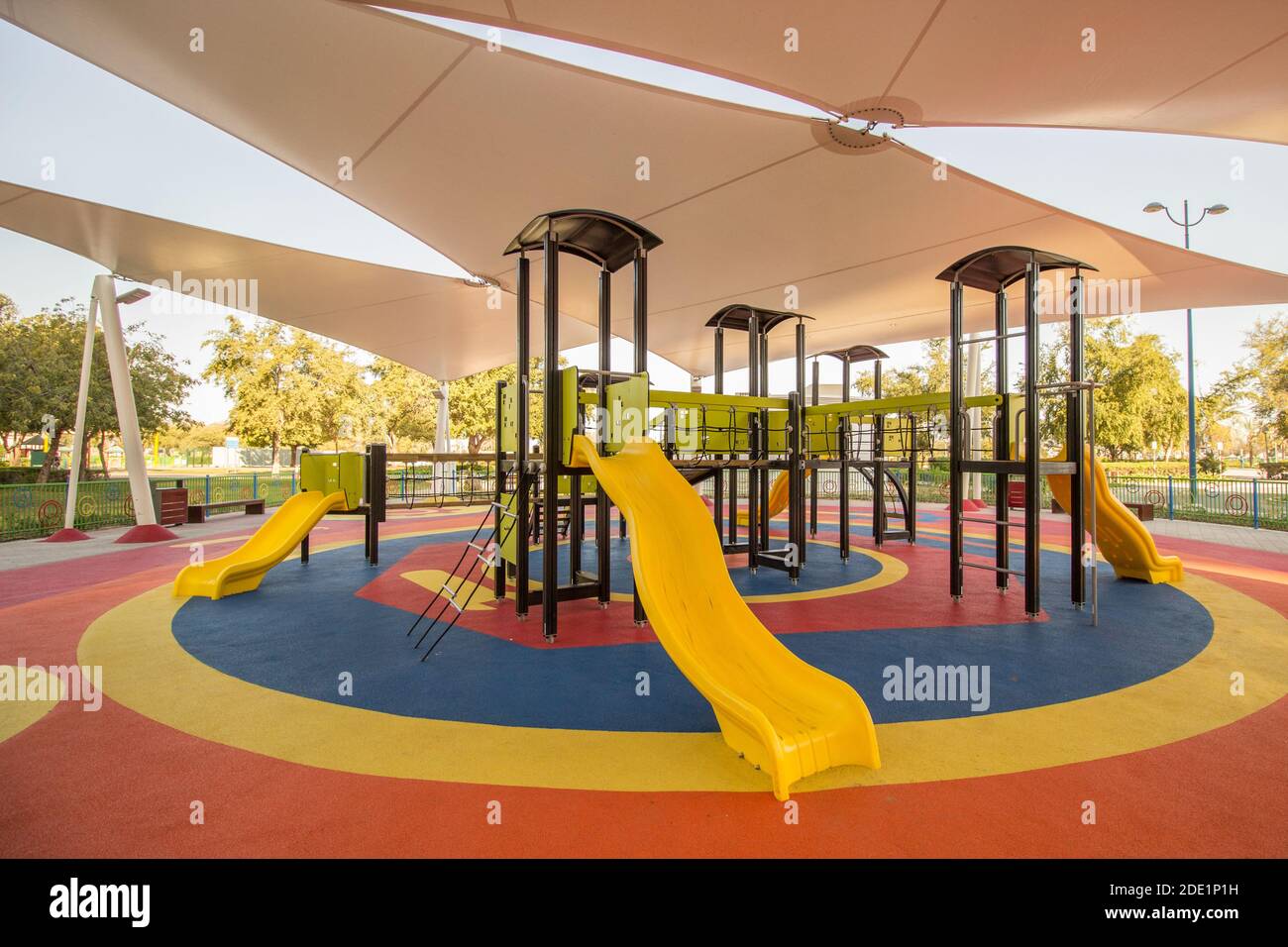 Shaded kid's playground activity tower equipment at the Lake park in ...