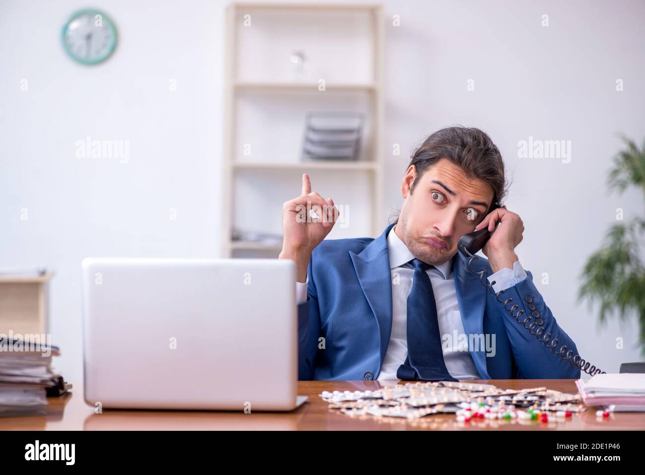 Sick male employee suffering at workplace Stock Photo - Alamy