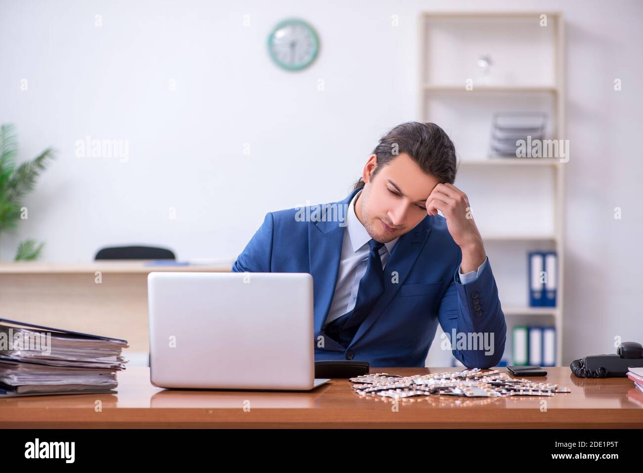 Sick male employee suffering at workplace Stock Photo - Alamy