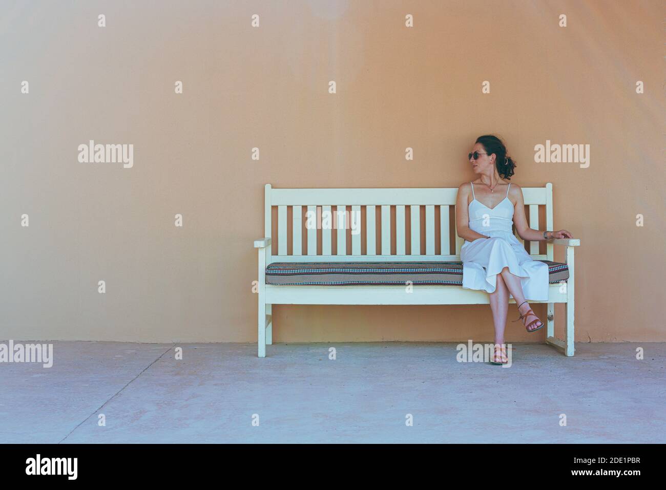 A young lady seats on the traditional Arabic bench under the porch at ...