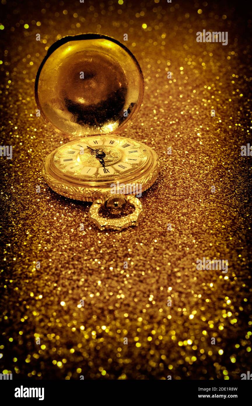 Old gold pocket watch laying on golden sparkling stars carpet Stock ...
