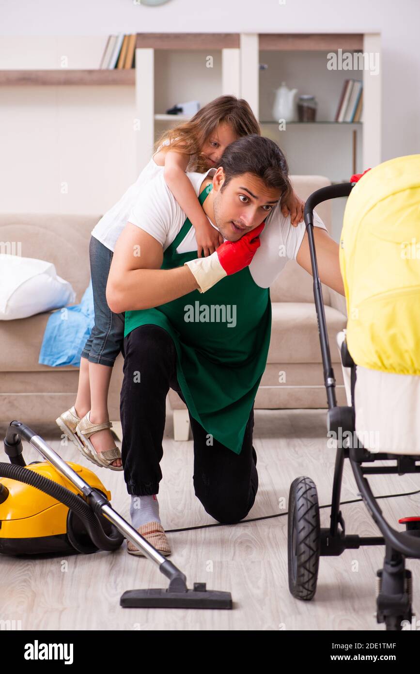 Young contractor cleaning the house with his small daughter Stock Photo ...