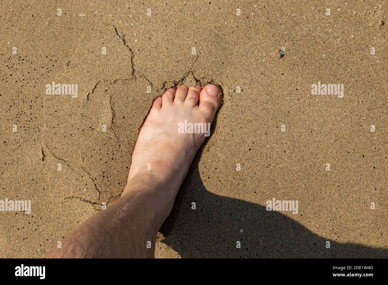 Wet foot on the golden sand of the beach, Ios Island, Greece Stock ...
