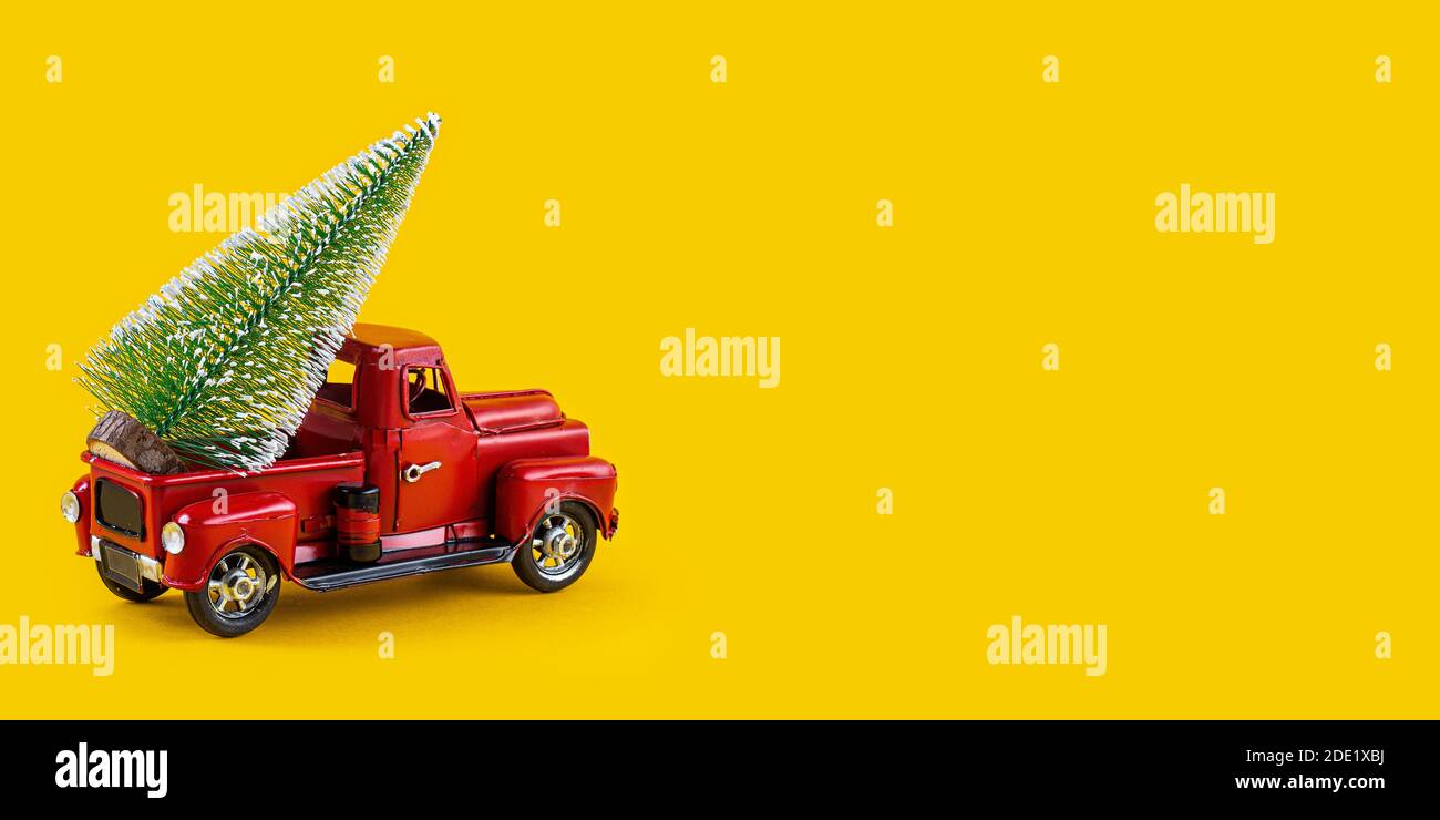 Red retro toy truck with Christmas tree on truck body on yellow ...