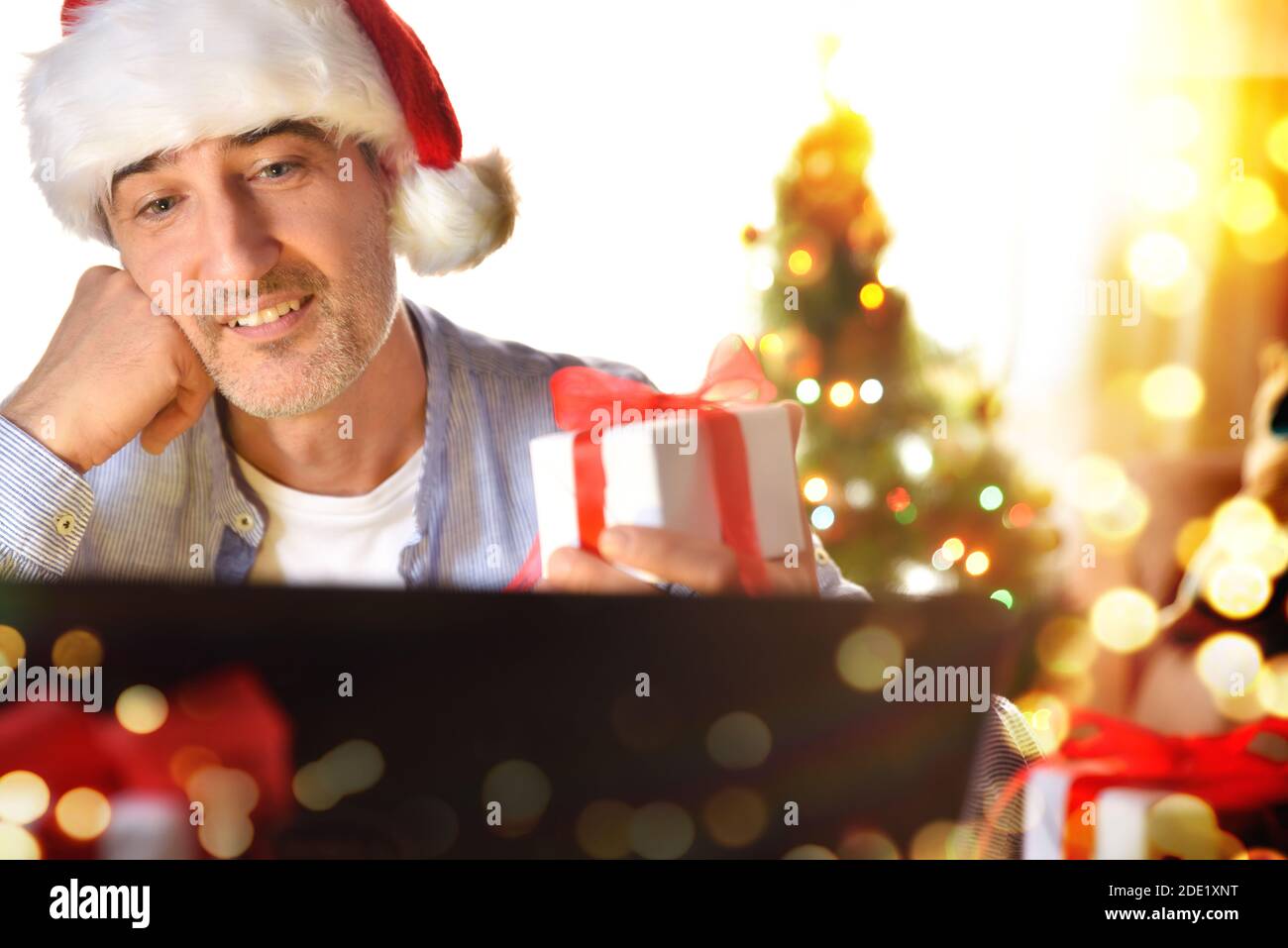 Self-absorbed man looking at a christmas present with wish. Front view ...