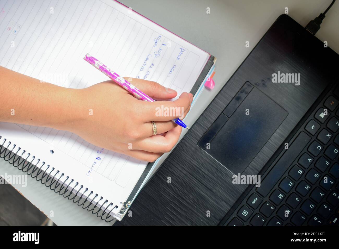 A top view shot of female writing some notes in a notebook from a ...