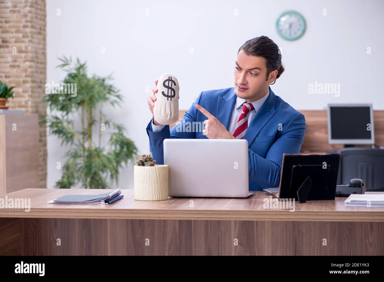 Young employee in remuneration concept Stock Photo - Alamy