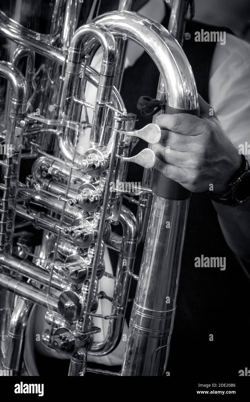 Close up black & white image of a man playing a tuba in the Hofbräuhaus ...