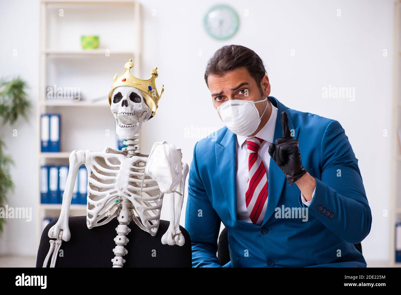 Businessman and skeleton in the office in pandemic concept Stock Photo ...