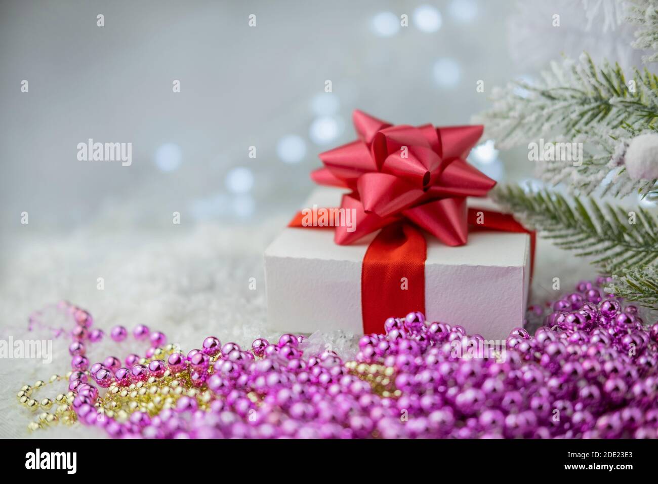 surprise gift with red bow on snow on bokeh background for winter ...
