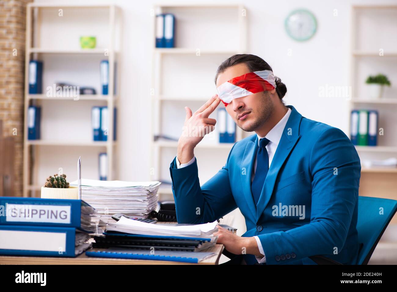 Blindfolded employee working in the office Stock Photo - Alamy