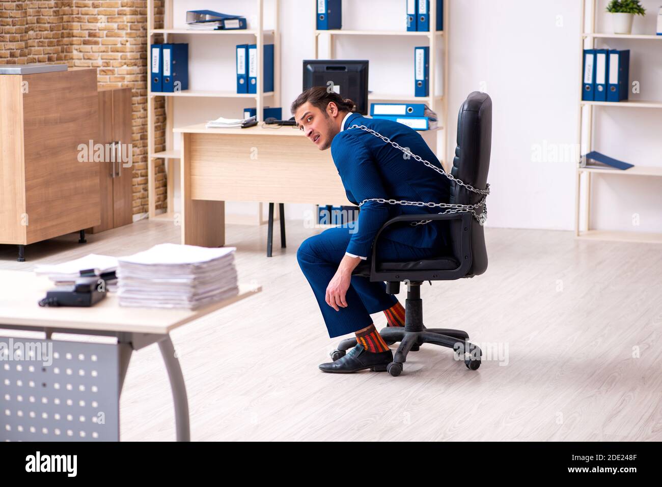 Chained employee working in the office Stock Photo - Alamy