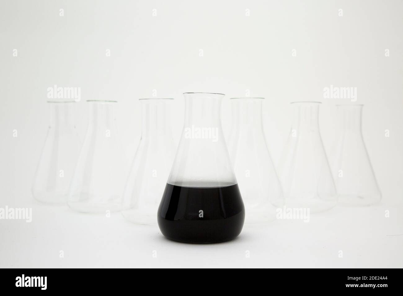 Scientific laboratory glass erlenmeyer flask filled with black liquid ...
