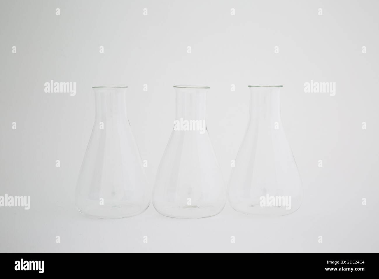 Three scientific laboratory glass erlenmeyer flask isolated on white ...