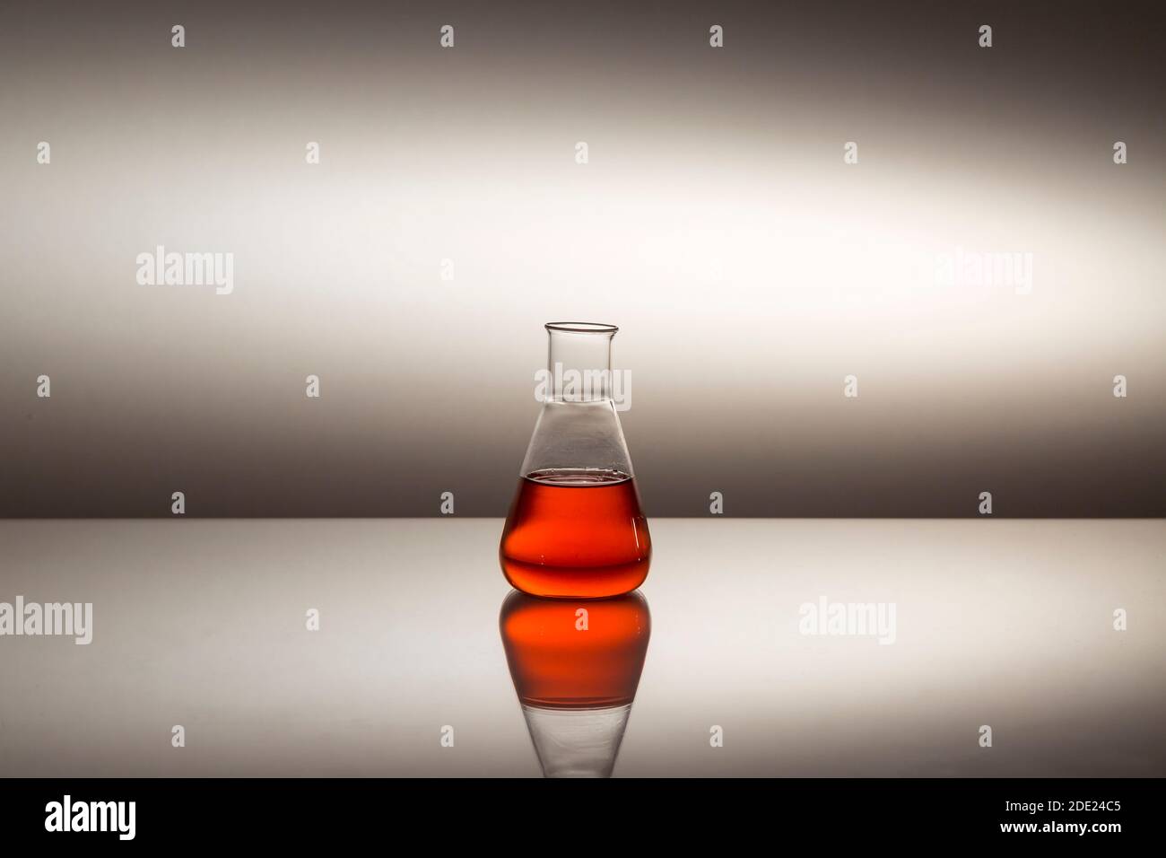 Scientific laboratory glass erlenmeyer flask filled with red liquid on ...