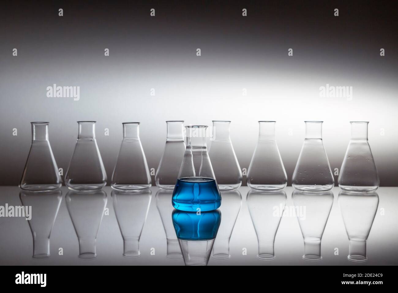 Scientific laboratory glass erlenmeyer flask filled with blue liquid ...