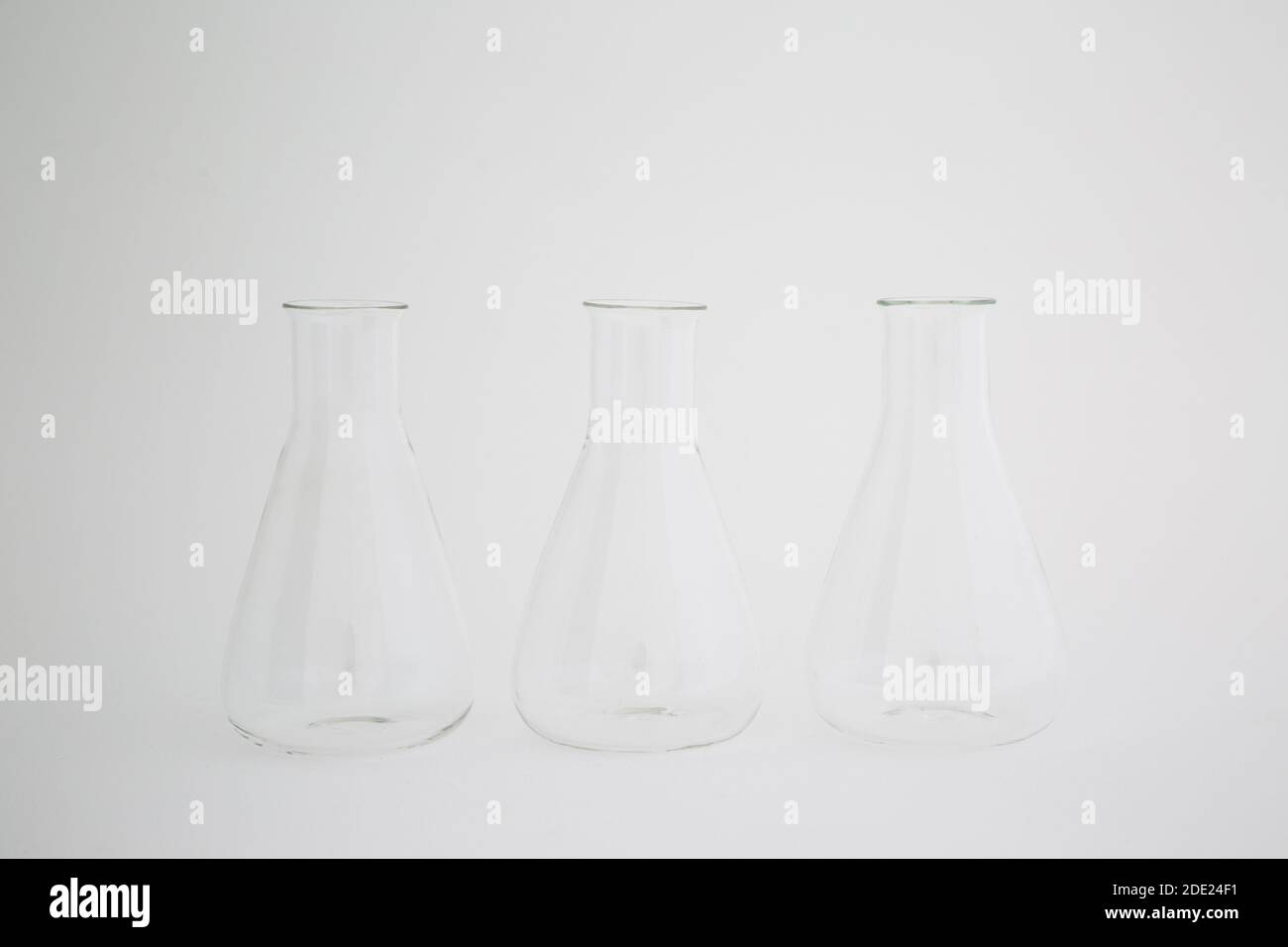 Three scientific laboratory glass erlenmeyer flask isolated on white ...