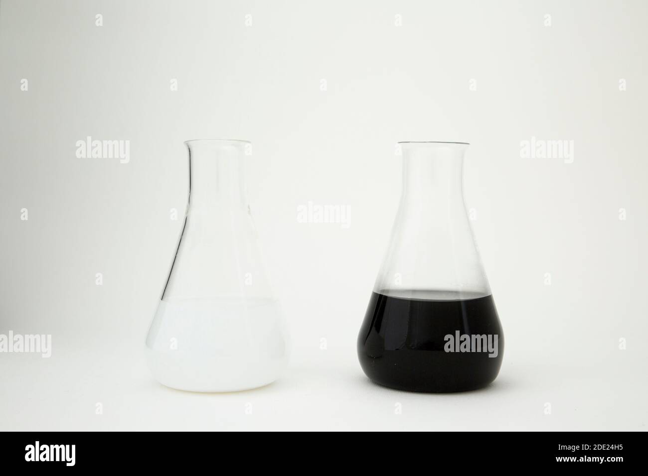 Scientific laboratory glass erlenmeyer flask filled with white and ...
