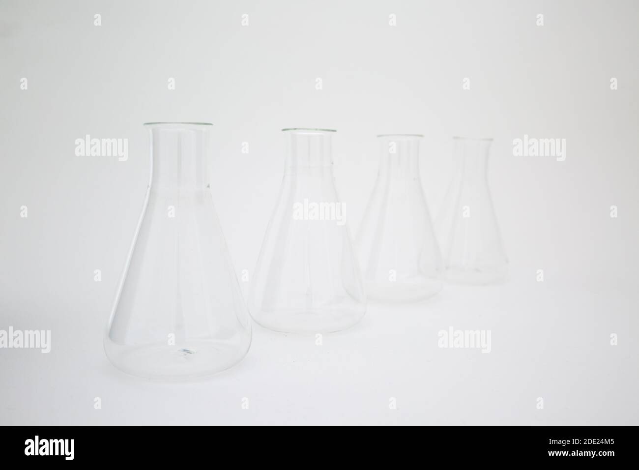 Row of scientific laboratory glass erlenmeyer flask isolated on white ...