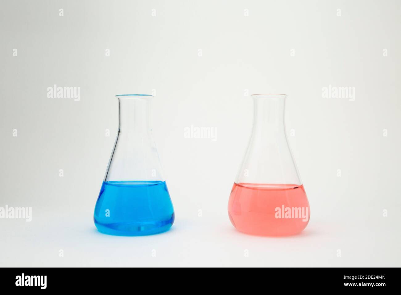 Scientific laboratory glass erlenmeyer flask filled with blue and pink ...