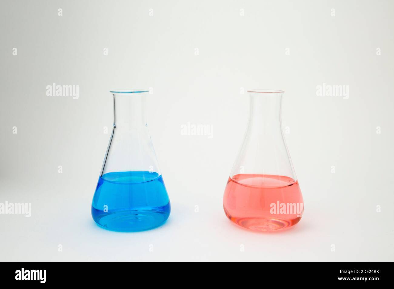 Scientific laboratory glass erlenmeyer flask filled with blue and pink ...