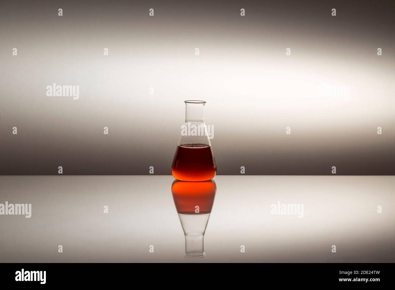 Scientific laboratory glass erlenmeyer flask filled with red liquid on ...