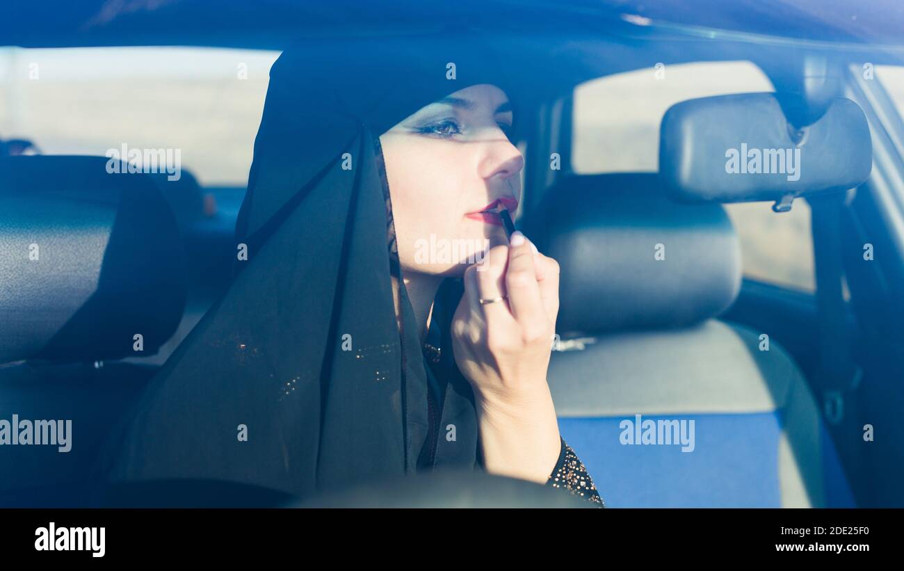 Woman driver paints lips in the car looks in the mirror y Stock Photo ...