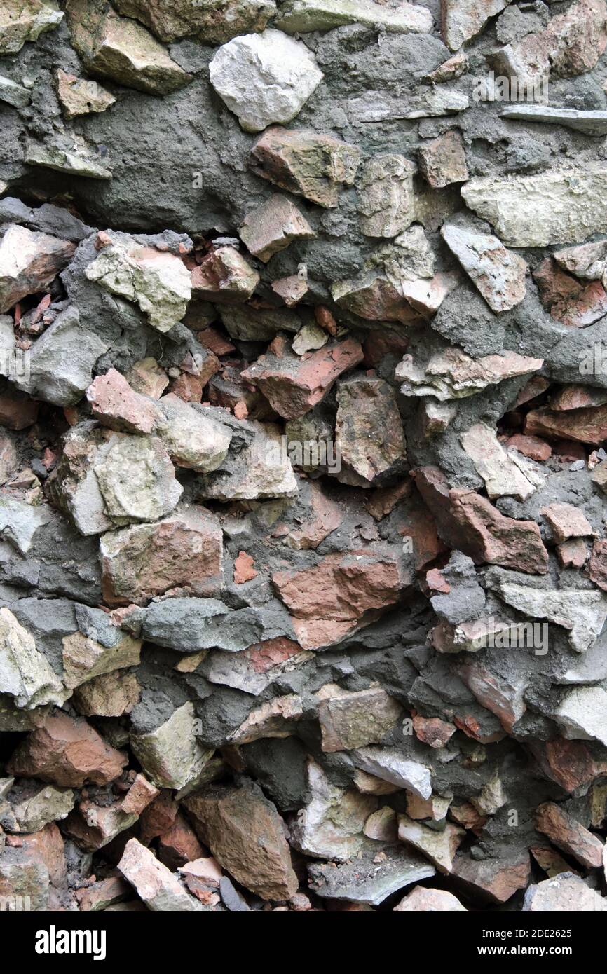 Cement mix with fragments of broken brick and stones as a background ...