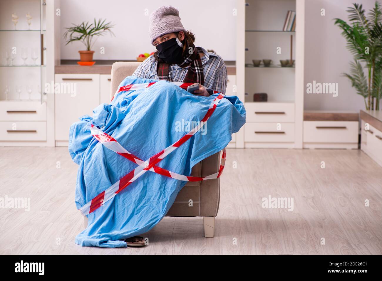 Sick man watching tv at home in pandemic concept Stock Photo - Alamy