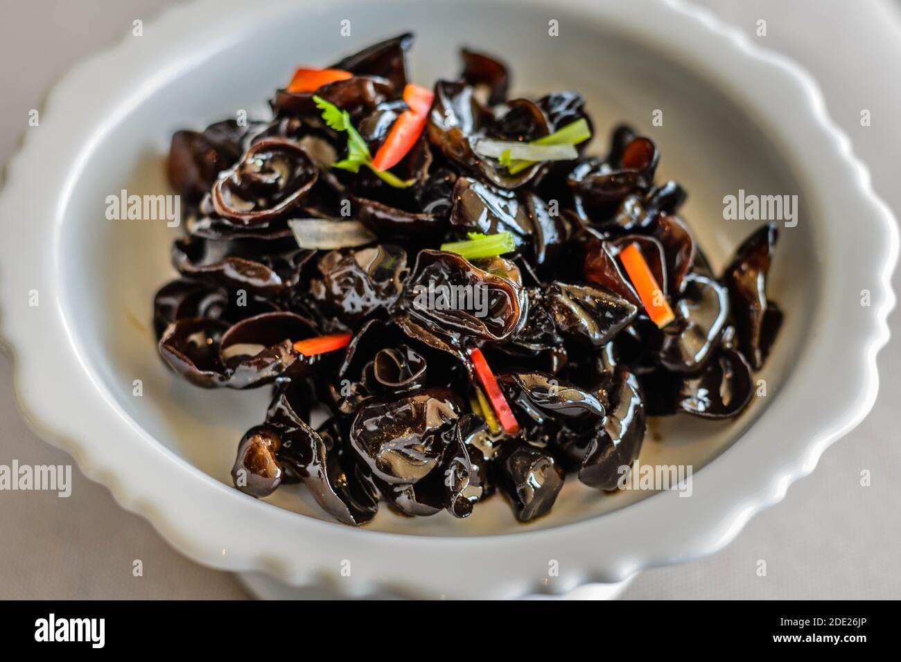 an appetiser of Fungus with Preserved Vinegar served in a white china ...