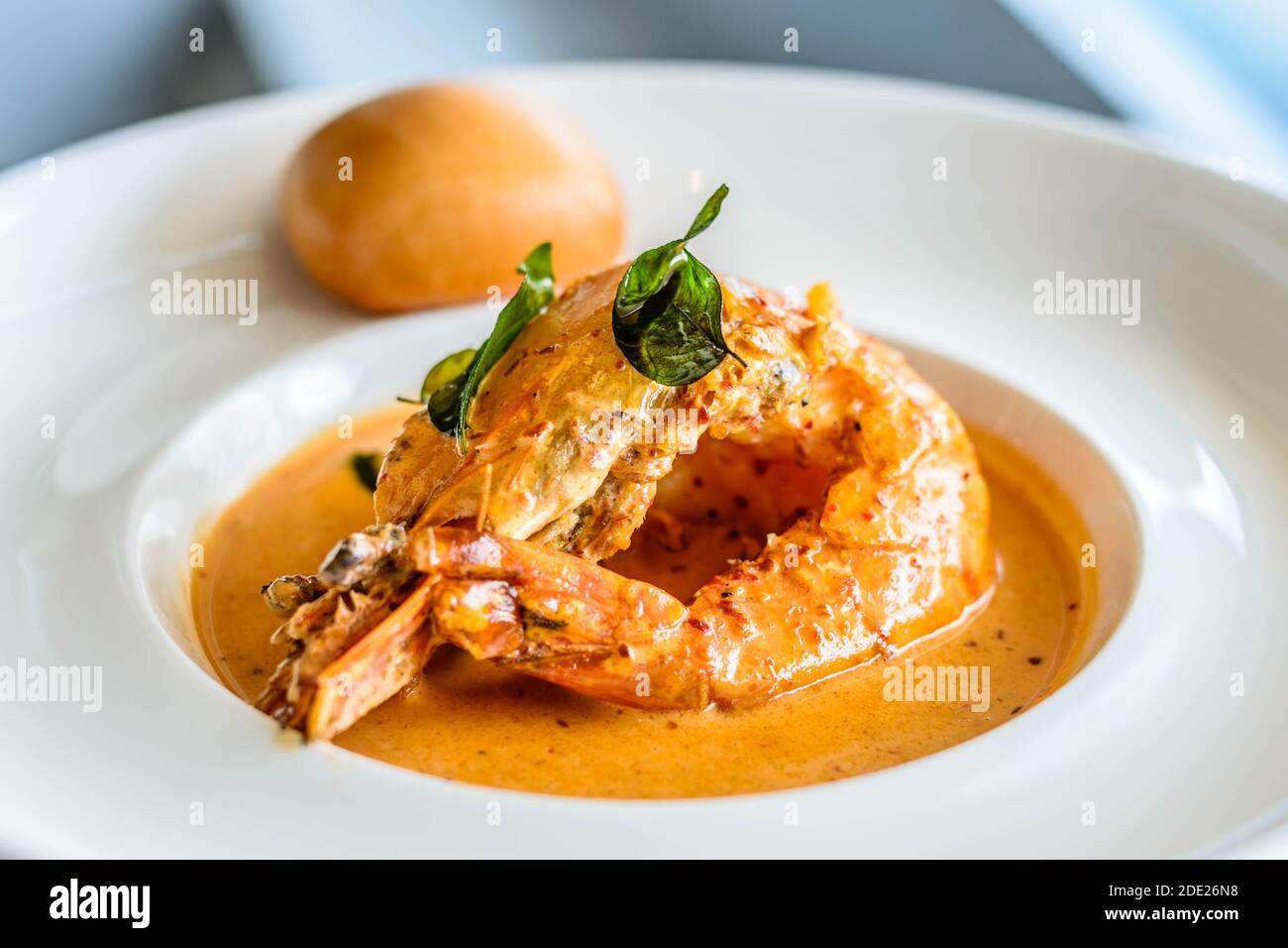 main course of King Prawn served in Bang Sauce with a bun Stock Photo ...