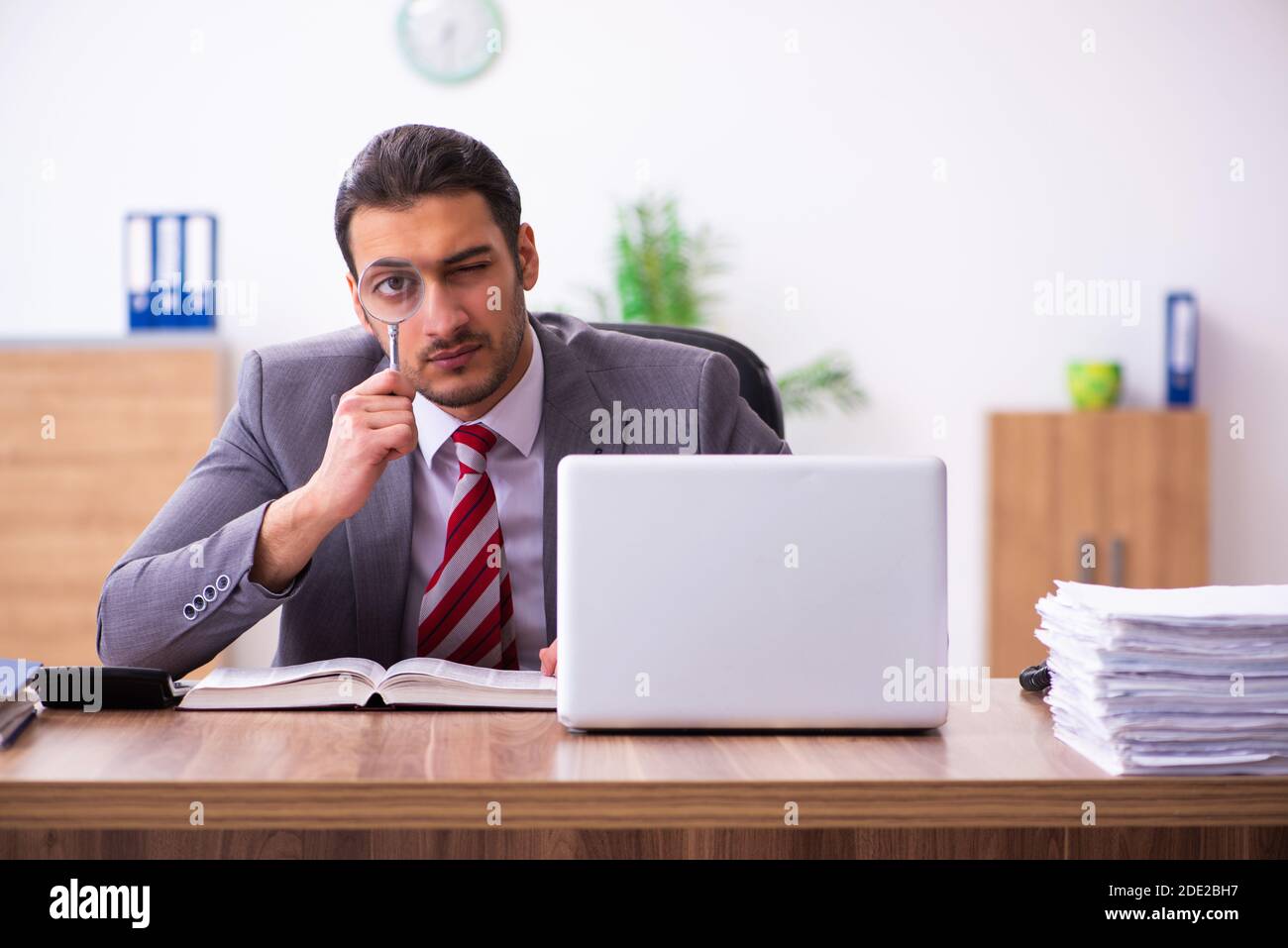 Male employee reading book in the office Stock Photo - Alamy