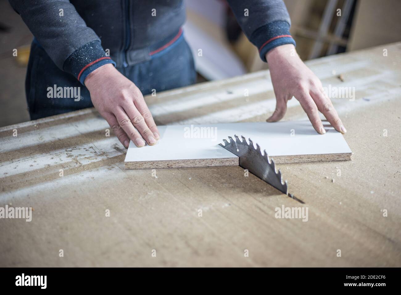 Close-up of a wooden cutting table with an electric circular saw ...