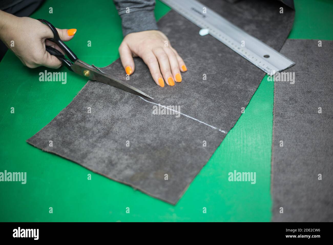 Woman's hand cuts a piece of fabric before sewing - scene with sewing ...