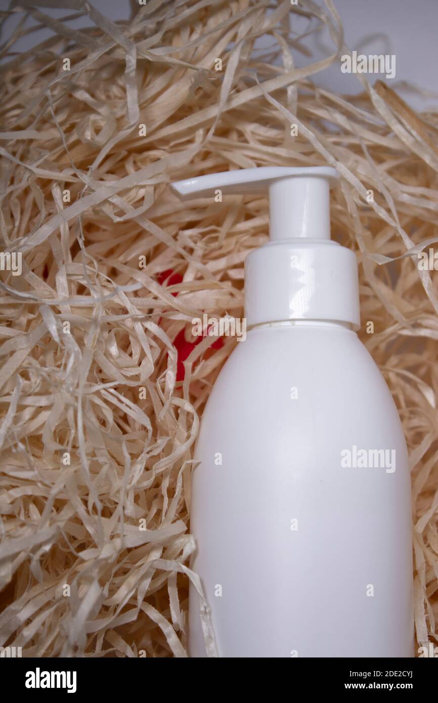 empty white shampoo bottle with no label in dried grass. body care and ...