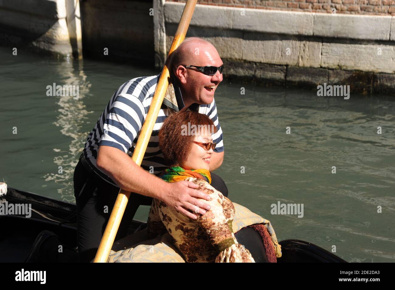 Happy tourist posing for a photo with a Gondolier in Venice, Italy ...