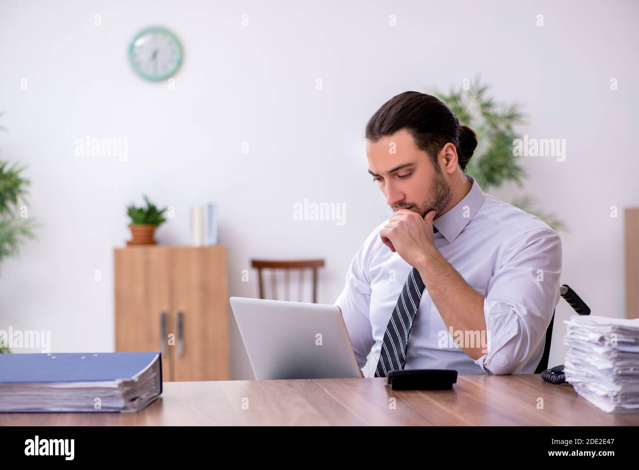 Young disabled employee suffering at the workplace Stock Photo - Alamy