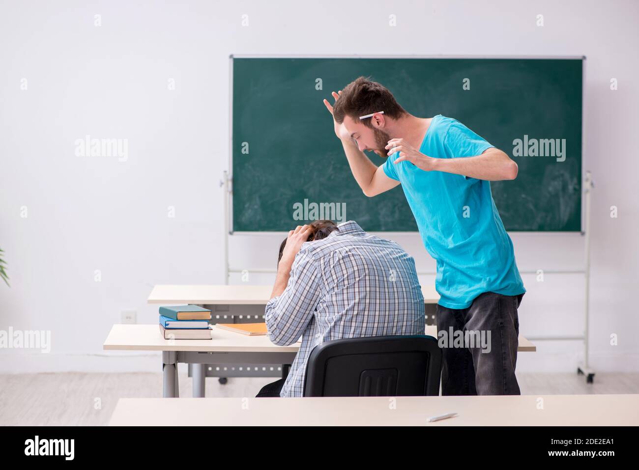 Male pupils in bullying concept in the classroom Stock Photo - Alamy