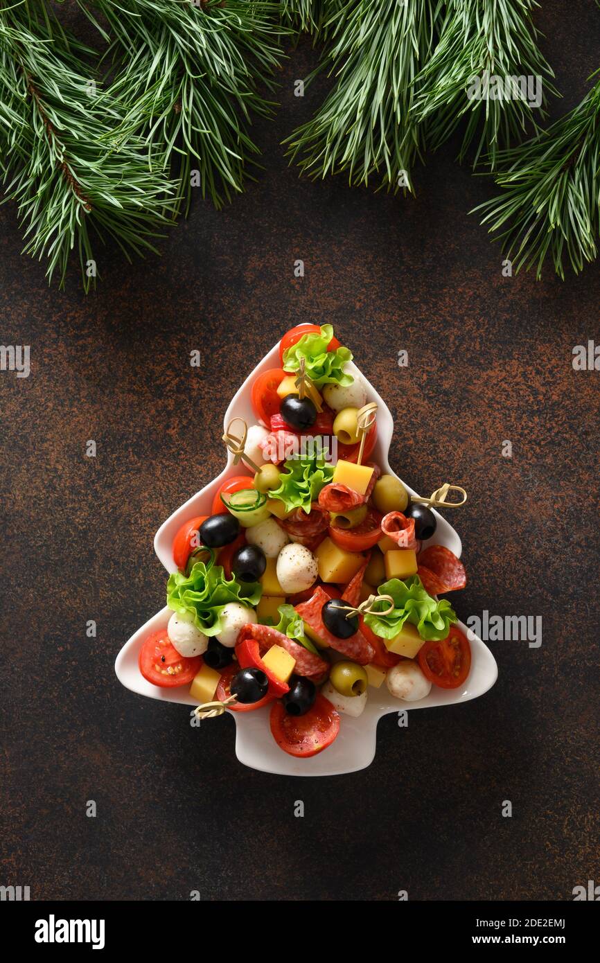 Holiday snacks as canapes in shape of Christmas tree plate for festive ...