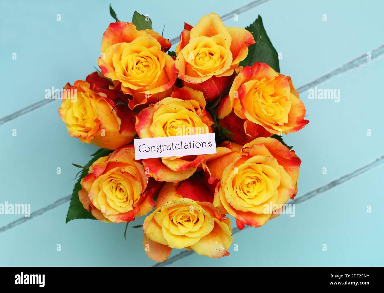 Congratulations card with colorful rose bouquet on blue wooden surface ...