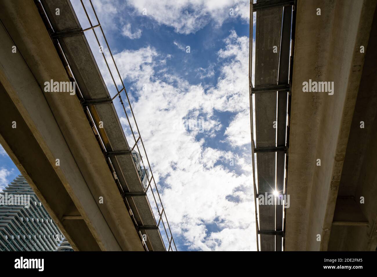 Low angle photo under railroad tracks Miami Metrorail with sun glare ...