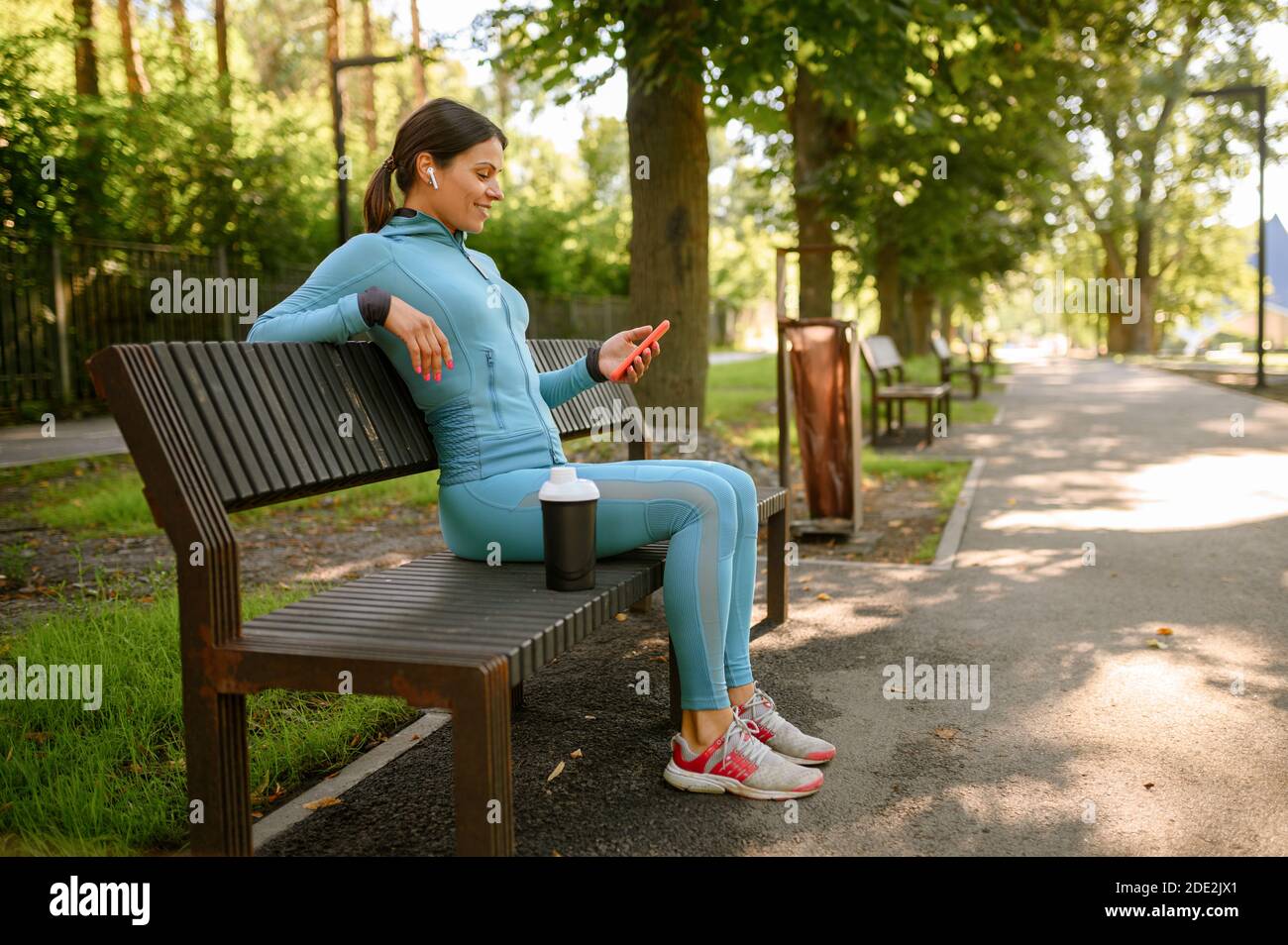 Woman relax on bench after morning workout in park Stock Photo - Alamy
