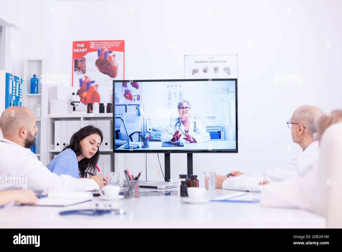 Group of doctors discussing with expert during video conference from ...