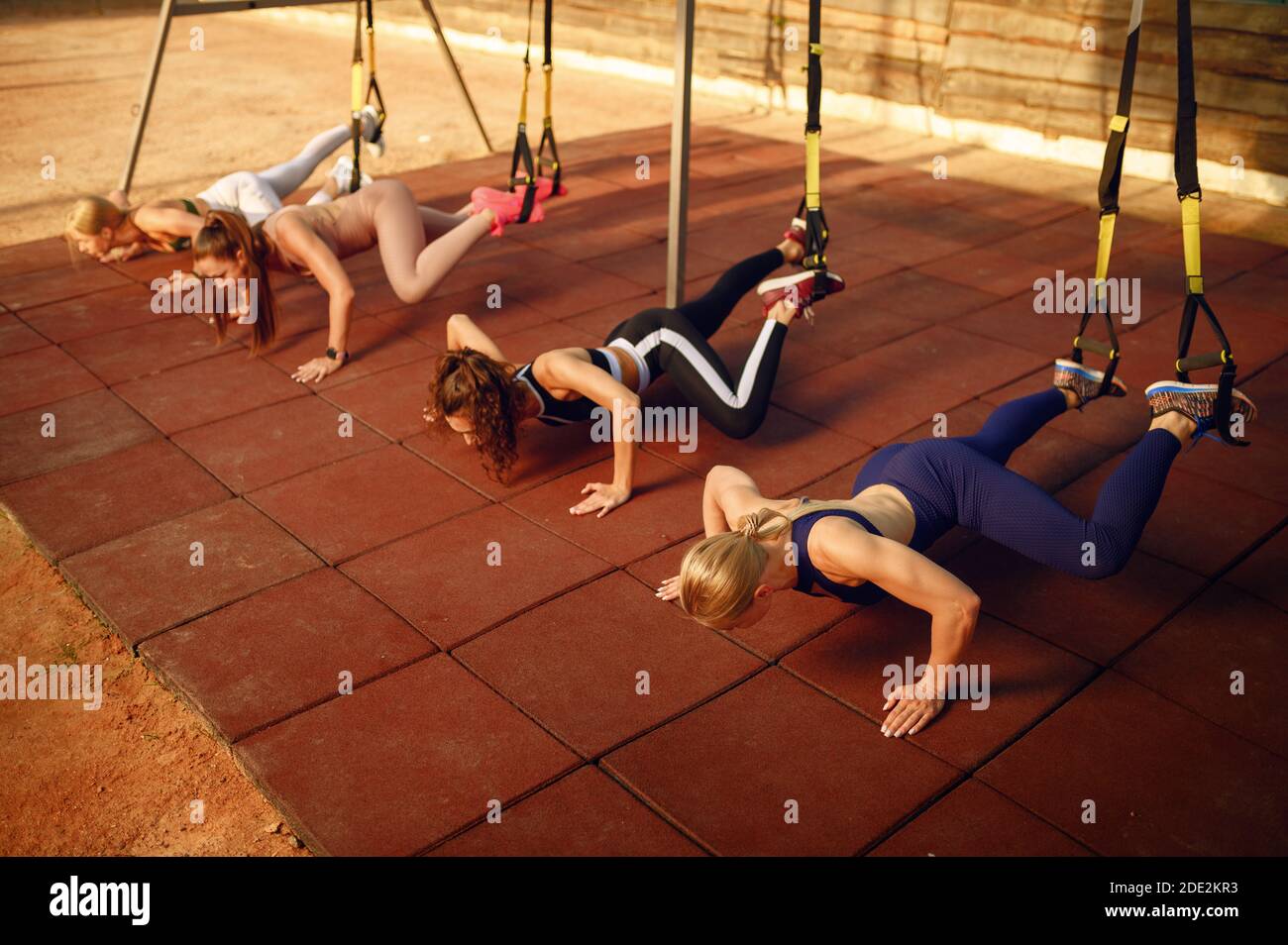 Women's group doing push-ups outdoors, front view Stock Photo - Alamy