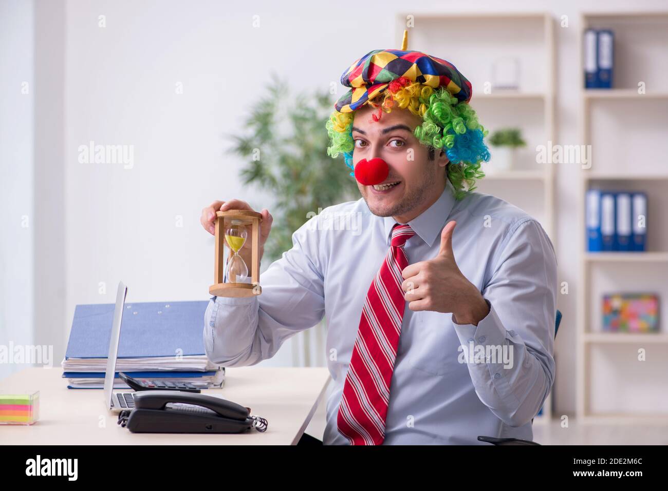 Funny employee clown working in the office room Stock Photo - Alamy