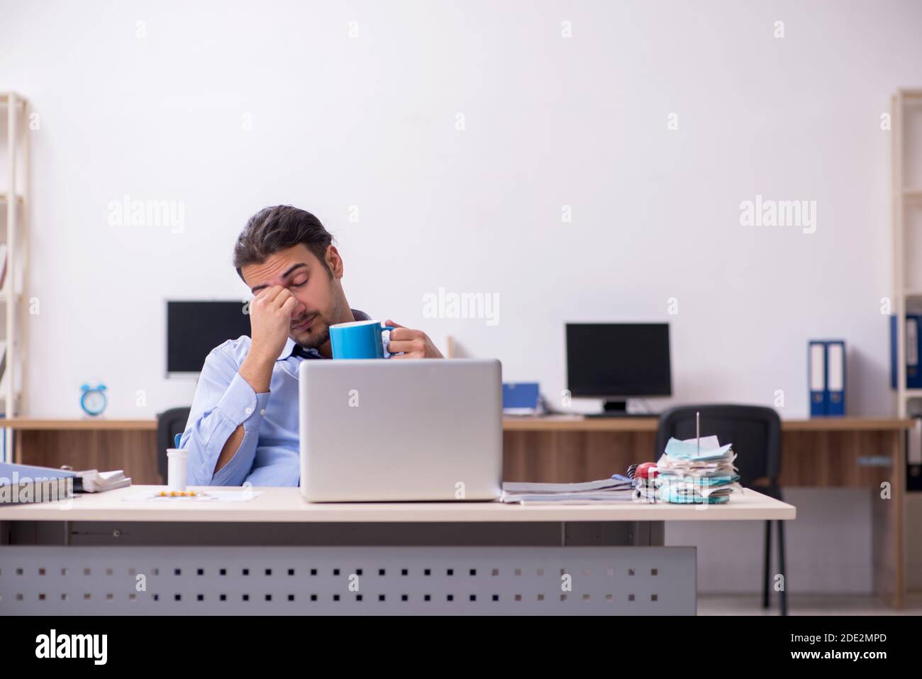 Sick male employee suffering at the workplace Stock Photo - Alamy