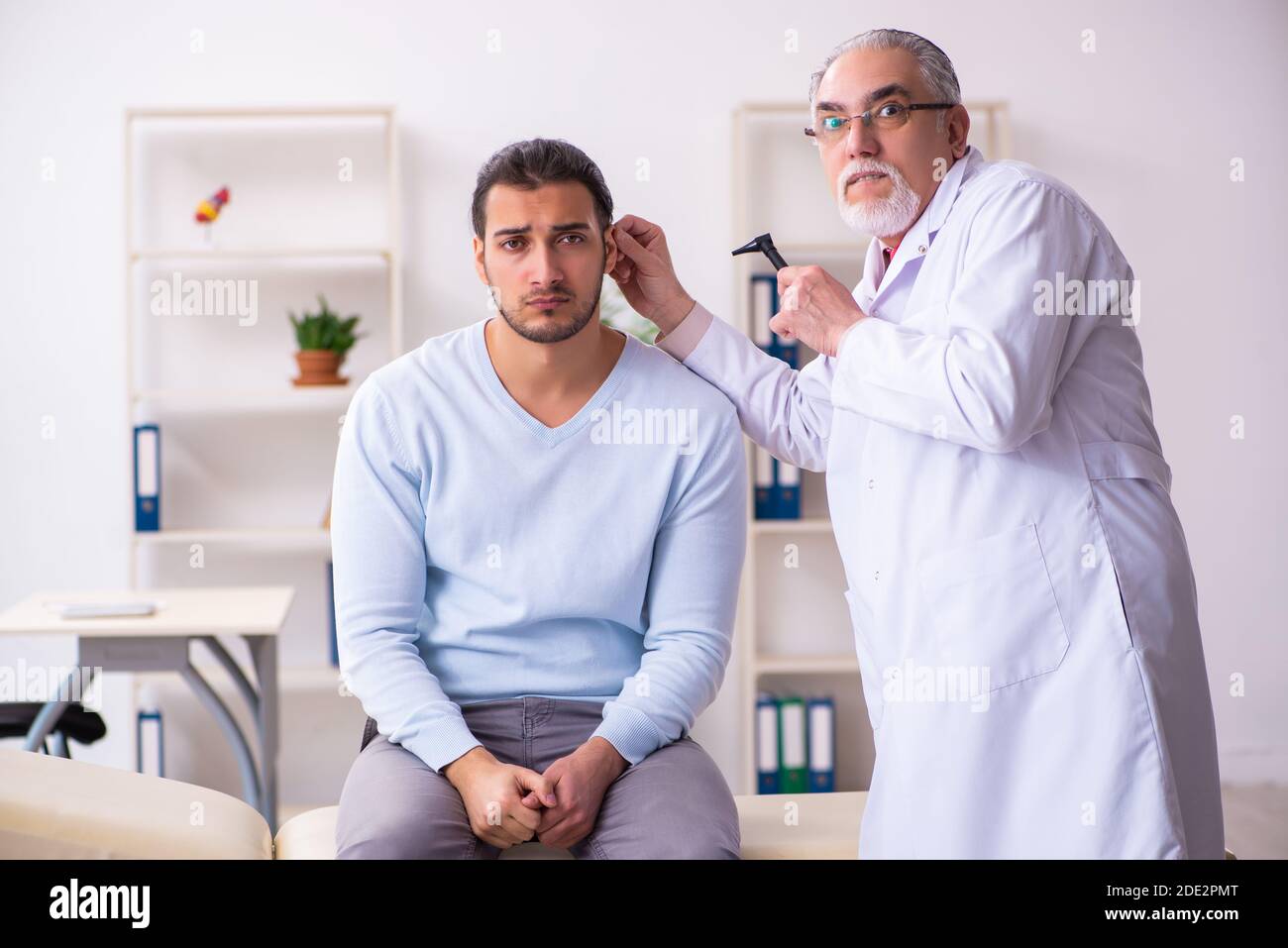 Sick man visiting old doctor otolaryngologist Stock Photo - Alamy