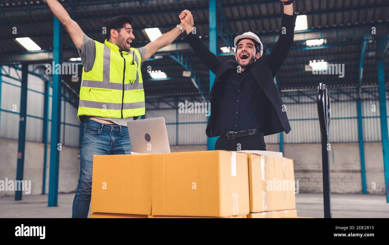 Two factory worker celebrate success together in the factory or ...