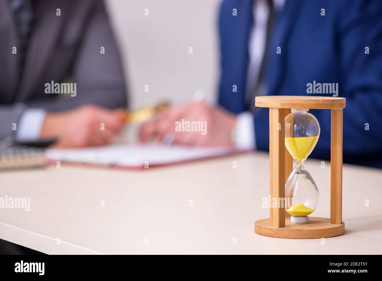 Two businessmen in the time management concept Stock Photo - Alamy